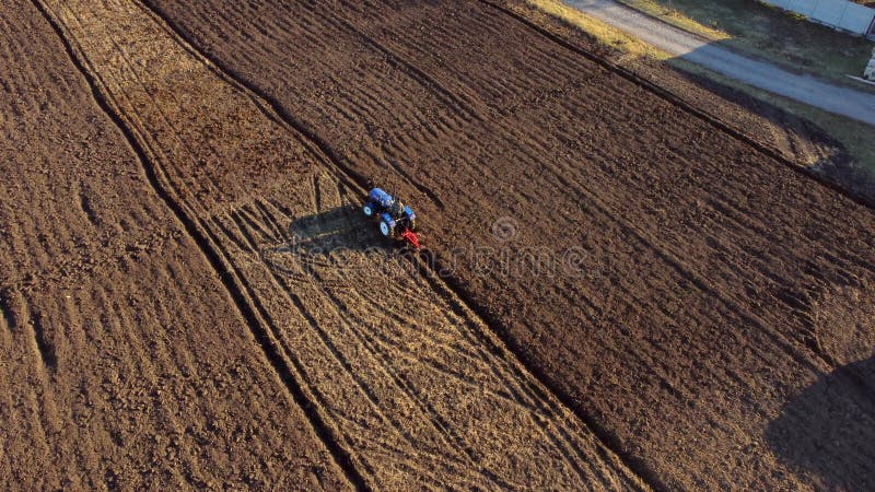 A Man on a Tractor Digging the Ground. Tractor Driver Plowing the Field ...