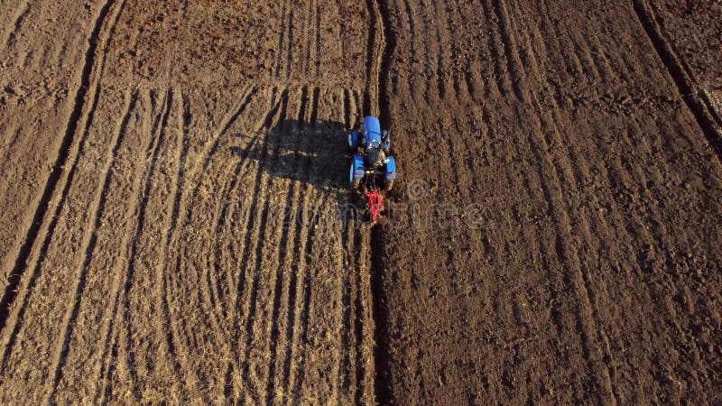 A Man on a Tractor Digging the Ground. Tractor Driver Plowing the Field ...