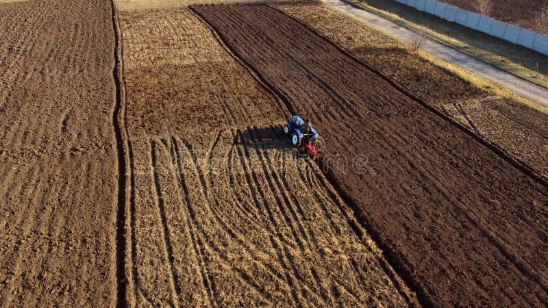 A Man on a Tractor Digging the Ground. Tractor Driver Plowing the Field ...