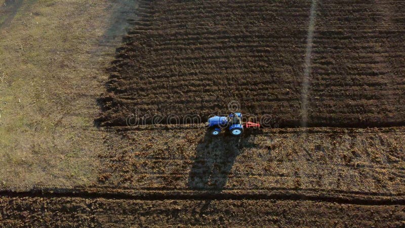 A Man on a Tractor Digging the Ground. Tractor Driver Plowing the Field ...