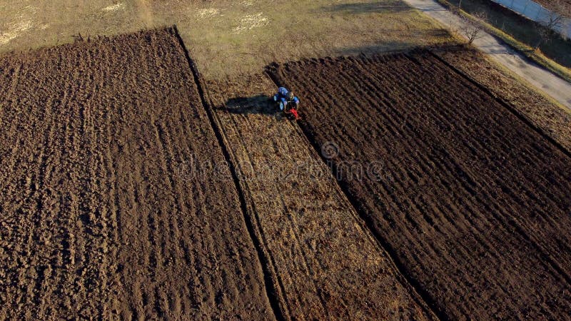 A Man on a Tractor Digging the Ground. Tractor Driver Plowing the Field ...