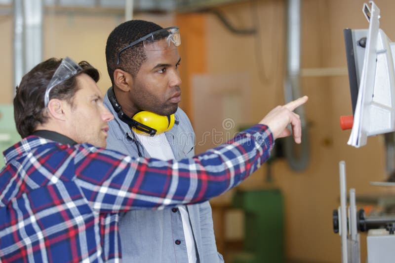 Man Training Apprentice To Use Machinery in Factory Stock Image - Image ...