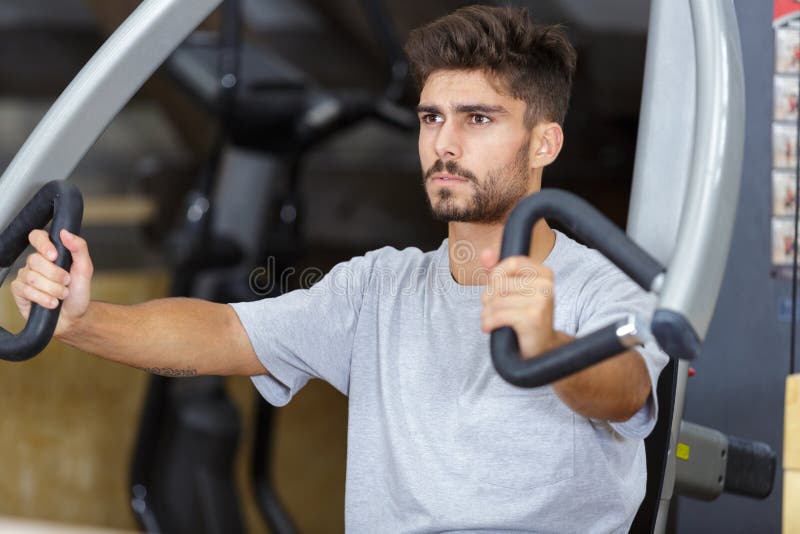 Man Training Biceps on Machine in Gym Stock Photo - Image of attractive ...