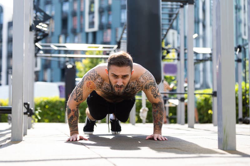 A Man Trains on the Street with Exercise Machines Stock Image - Image ...