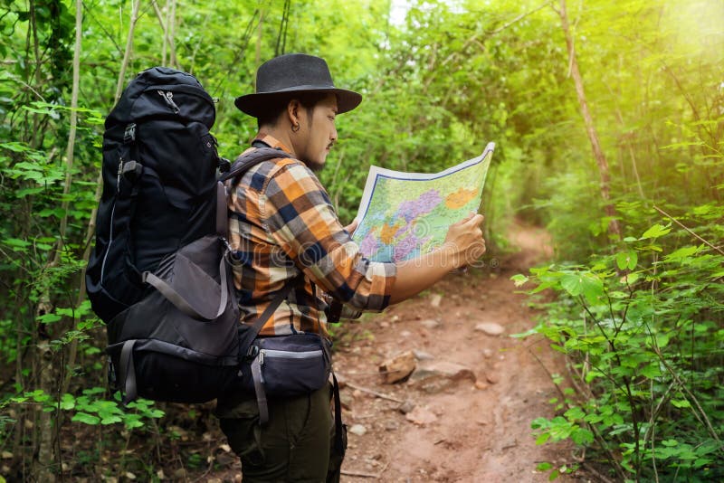 Man Traveler with Backpack and Map Searching Directions in the Forest ...