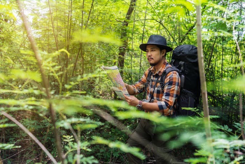 Man Traveler with Backpack and Map Searching Directions in the Forest ...