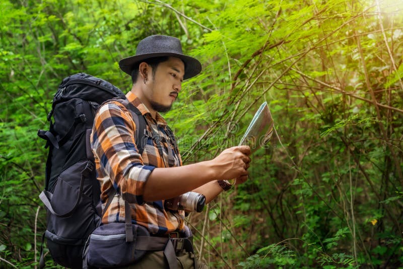 Man Traveler with Backpack and Map Searching Directions in the Forest ...