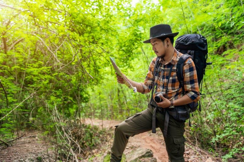 Man Traveler with Backpack and Map Searching Directions in the Forest ...