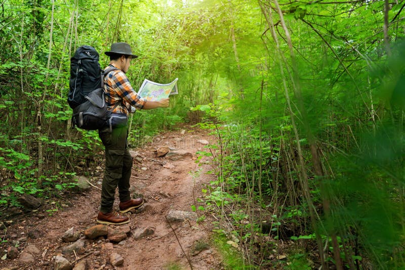 Man Traveler with Backpack and Map Searching Directions in the Forest ...