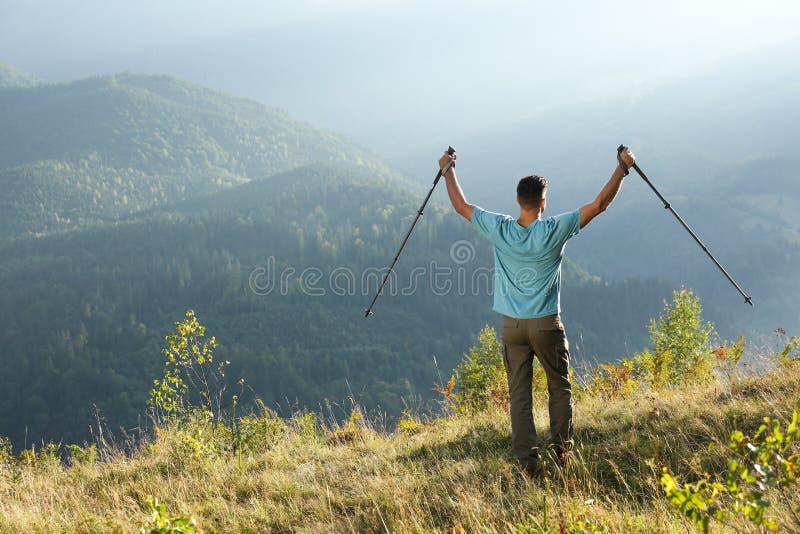 Man with Trekking Poles Hiking in Mountains, Back View. Space for Text ...