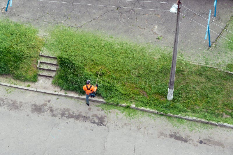 Man Trimmer Cuts Grass in the City, Top View Stock Photo - Image of ...