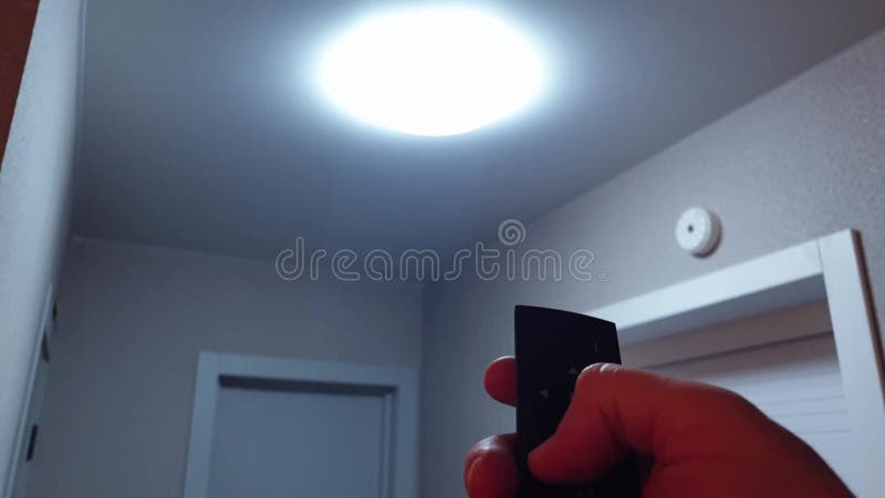 Man Turning on the Large Round LED Light in the Apartment with Remote ...
