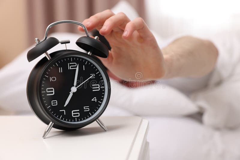 Man Turning Off Alarm Clock in Bedroom, Focus on Hand Stock Image ...