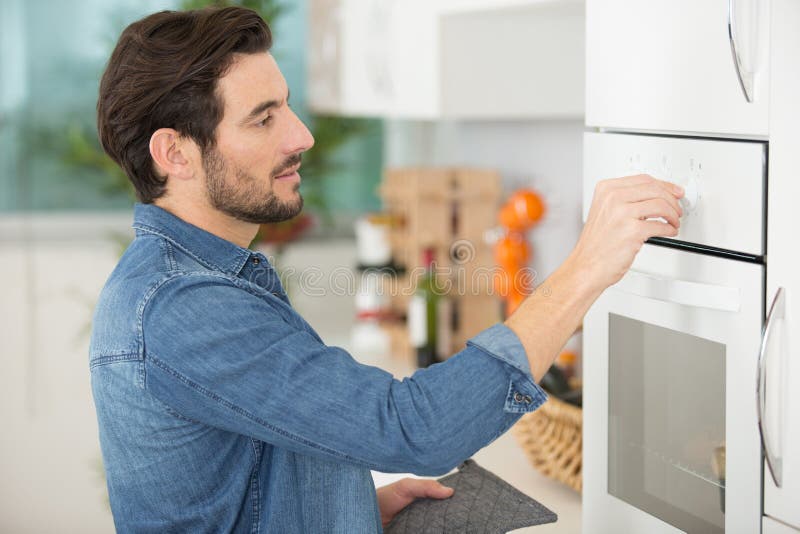 Man turning on oven stock image. Image of kitchen, control - 258546599
