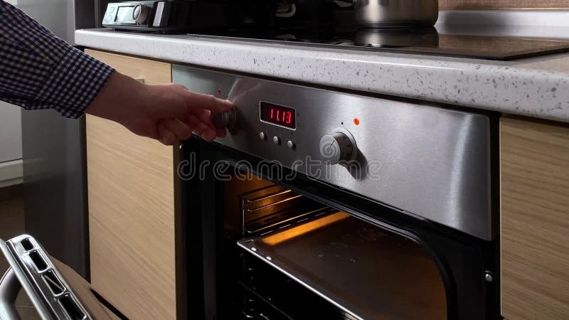 The Man Turns on the Electrical Oven in the Kitchen To Cook Food. we ...