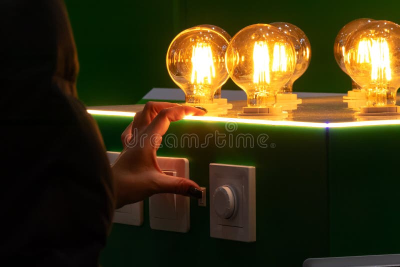 A Man Turns on Round Energy-efficient Light Bulbs in a Glass Bulb with ...