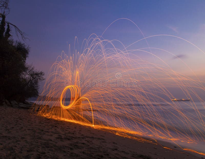 Man Twirling Fireworks on Beach Stock Photo - Image of arts, fires ...