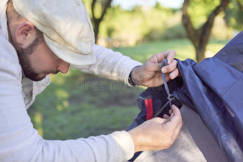 Man Tying the Rainfly of His Tent, in the Process of Setting it Up ...