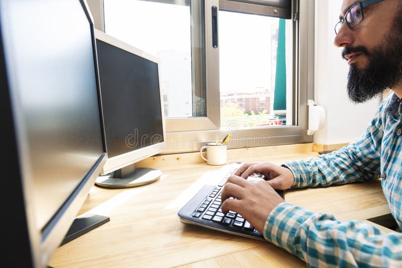 Man Typing on in Front of Two Computer Screens Stock Photo - Image of ...