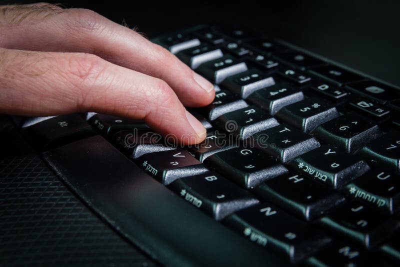 Man Typing on a Keyboard with Letters in Hebrew and English Stock Photo ...