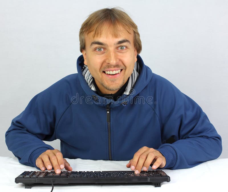 Man Typing on Keyboard and Smiling Stock Photo - Image of young, blue ...