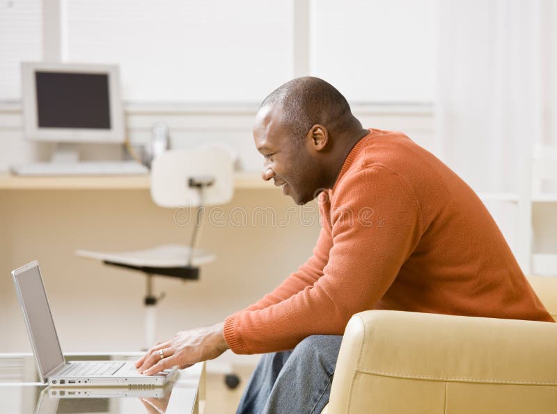 Man Typing on Laptop in Livingroom Stock Photo - Image of typist, male ...