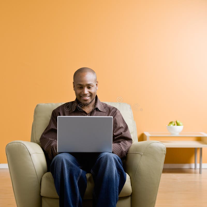 Man Typing on Laptop in Livingroom Stock Image - Image of livingroom ...