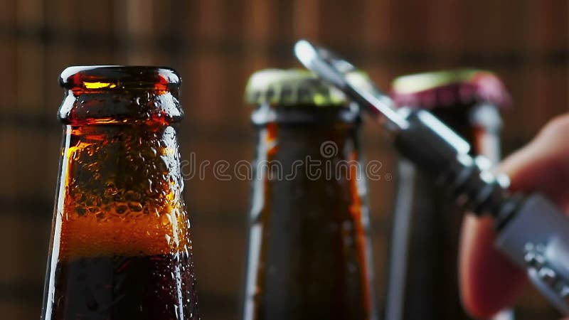 Man Uncap Three Bottles of Fresh Beer with Foam and Drops on Dark ...