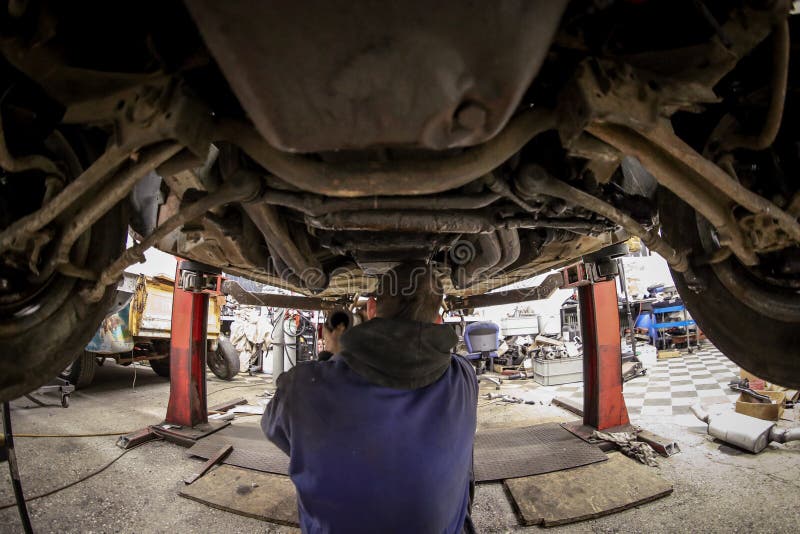 Man under a car on a lift stock image. Image of fixing - 186557933