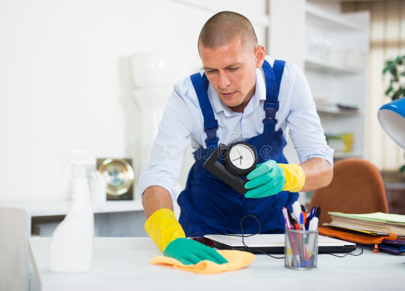 Man in Uniform is Cleaning Dust from the Desk in Office Stock Image ...