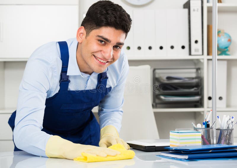 Man in Uniform is Cleaning Dust from the Desk Stock Photo - Image of ...