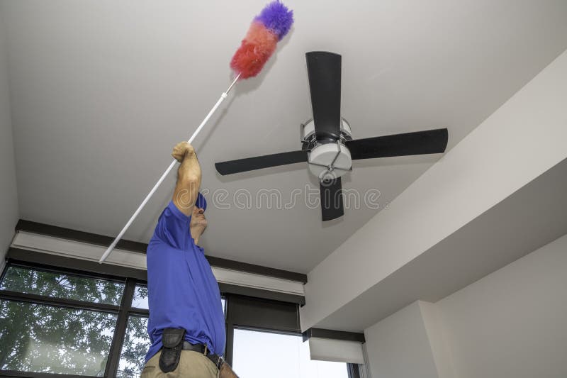 Man in Uniform Dusting a Fan Stock Image - Image of person, house ...