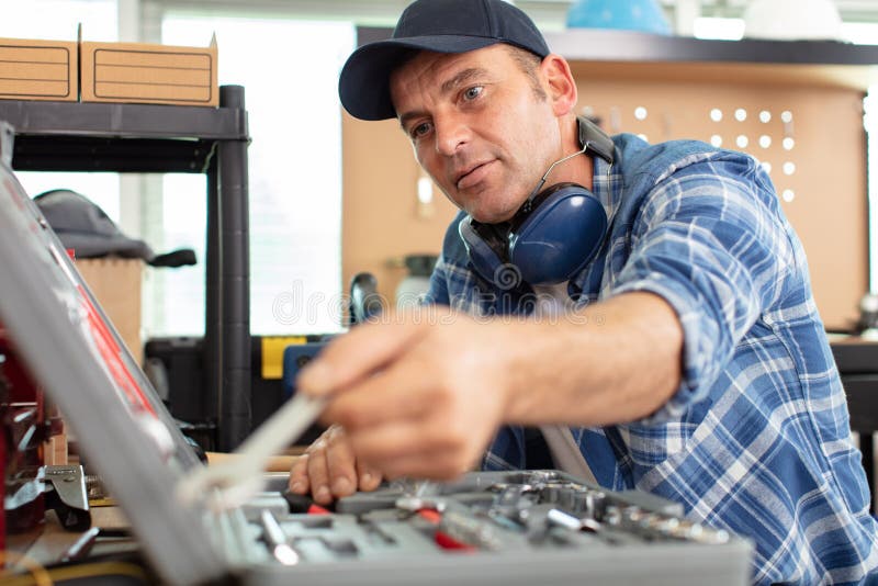 Man in Uniform Looks Inside Toolbox Stock Photo - Image of handyman ...