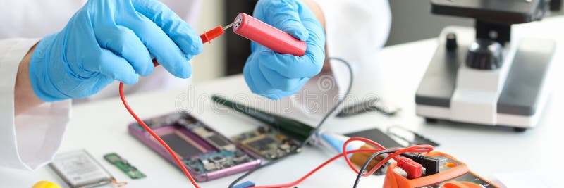 A Man in Uniform with Voltmeter and a Red Battery in His Hands Stock ...