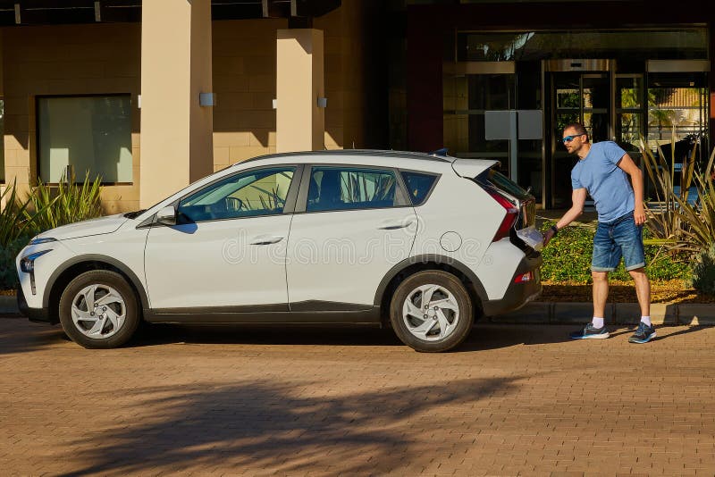 Man Unloading Suitcase from Car Outside Hotel Stock Photo - Image of ...
