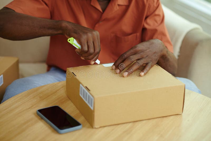 Man Unpacking Cardboard Box at Table Stock Photo - Image of package ...