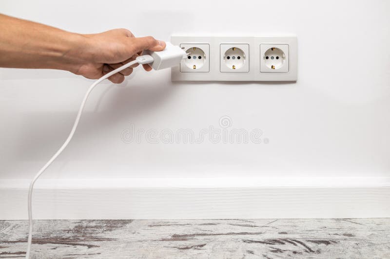 Man Unplugging Phone Adapter from a Electrical Outlet Stock Image ...