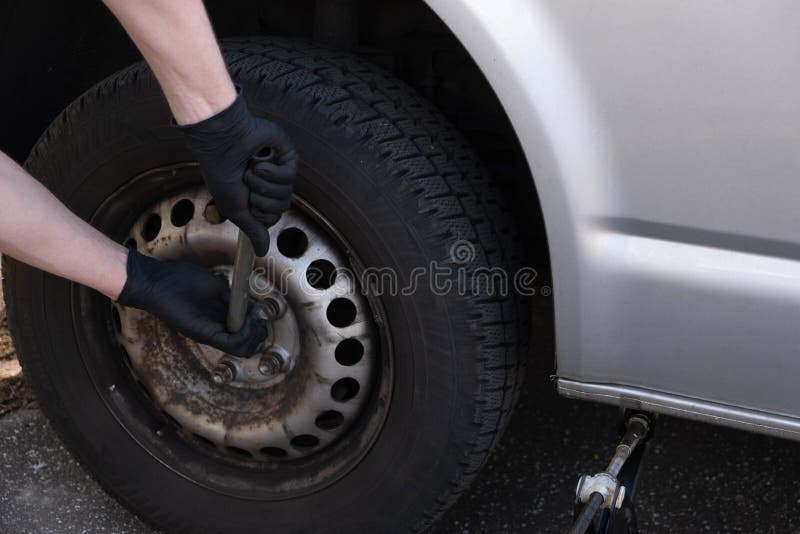 Man Unscrews the Nuts on the Wheel of a Car Stock Photo - Image of tire ...