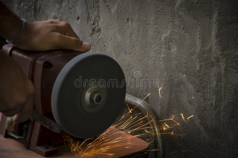 Man use a bench grinder. stock photo. Image of manufacture - 186243980