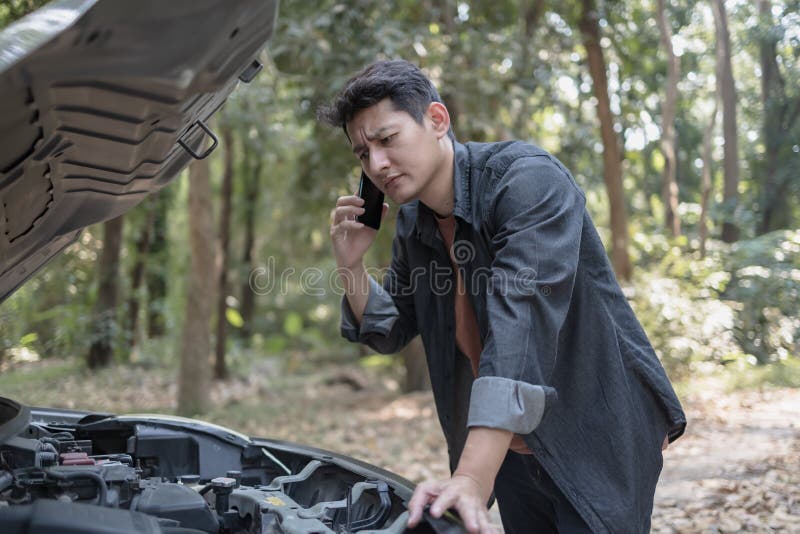 Man Usea Cellphone Call Garage in Front of the Open Hood of a Broken ...