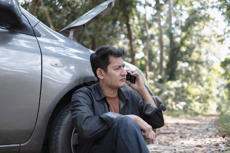 Man Usea Cellphone Call Garage in Front of the Open Hood of a Broken ...
