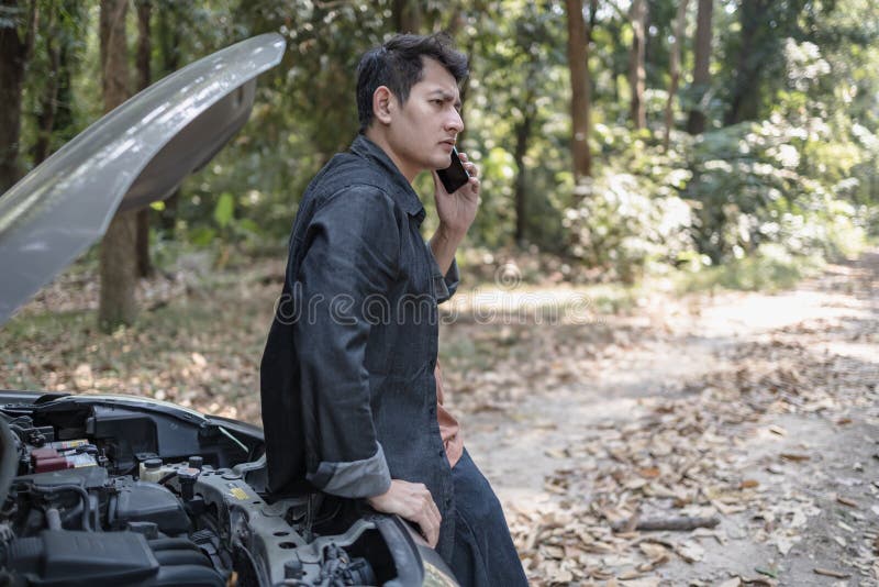 Man Usea Cellphone Call Garage in Front of the Open Hood of a Broken ...