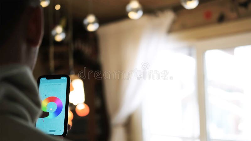 A Man Uses an Application on His Phone To Change the Color of ...