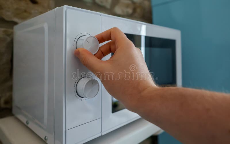 Man uses a microwave oven stock image. Image of invention - 272131855