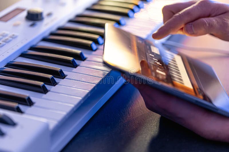 A Man Uses a Tablet with an Application for Recording Music. Stock ...