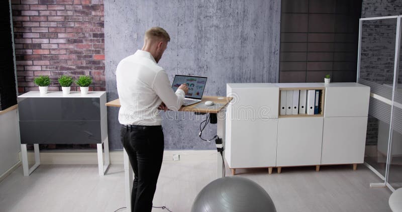 Man Using Adjustable Height Standing Desk in Office Stock Image - Image ...