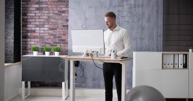 Man Using Adjustable Height Standing Desk in Office Stock Image - Image ...