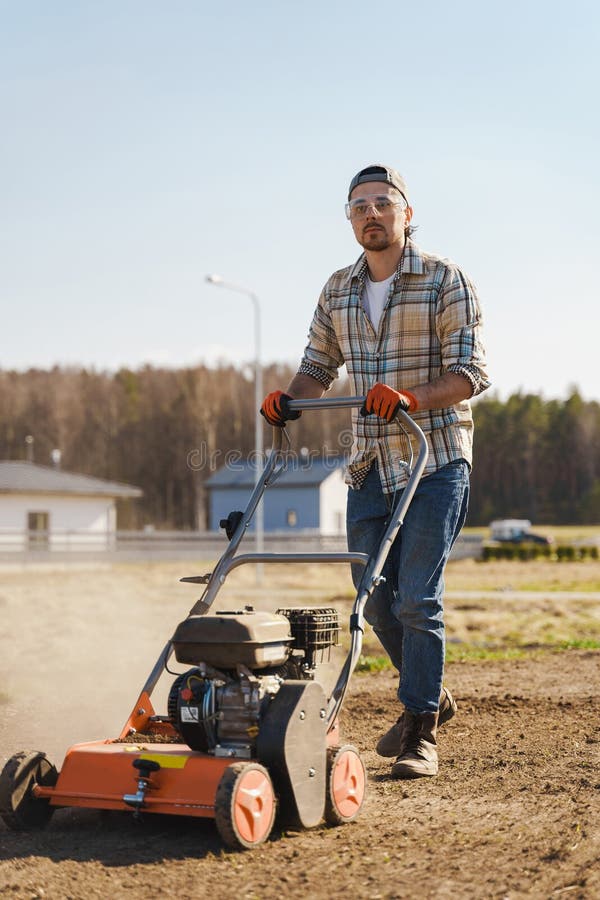 Man Using Aerator Machine To Scarification and Aeration of Lawn or ...