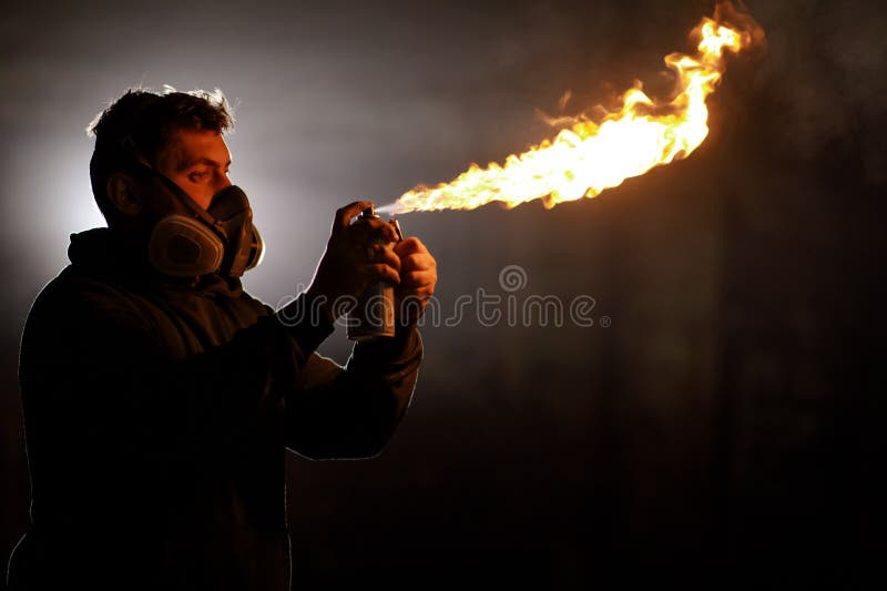 Man Using Aerosol Spray Can To Create Flame in a Dark Environment ...