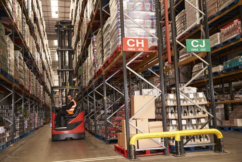 Man Using Aisle Truck in a Distribution Warehouse, Side View Stock ...